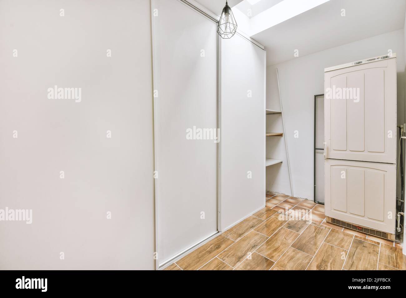 Empty narrow room with storage space, white cabinets, chandelier and ...