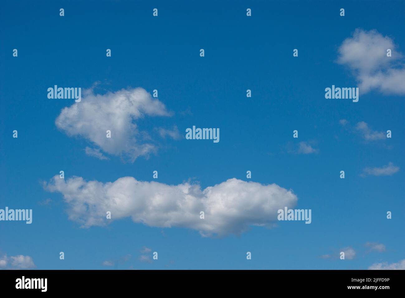 The horizontal photo is a blue sky with white fluffy clouds. Background ...