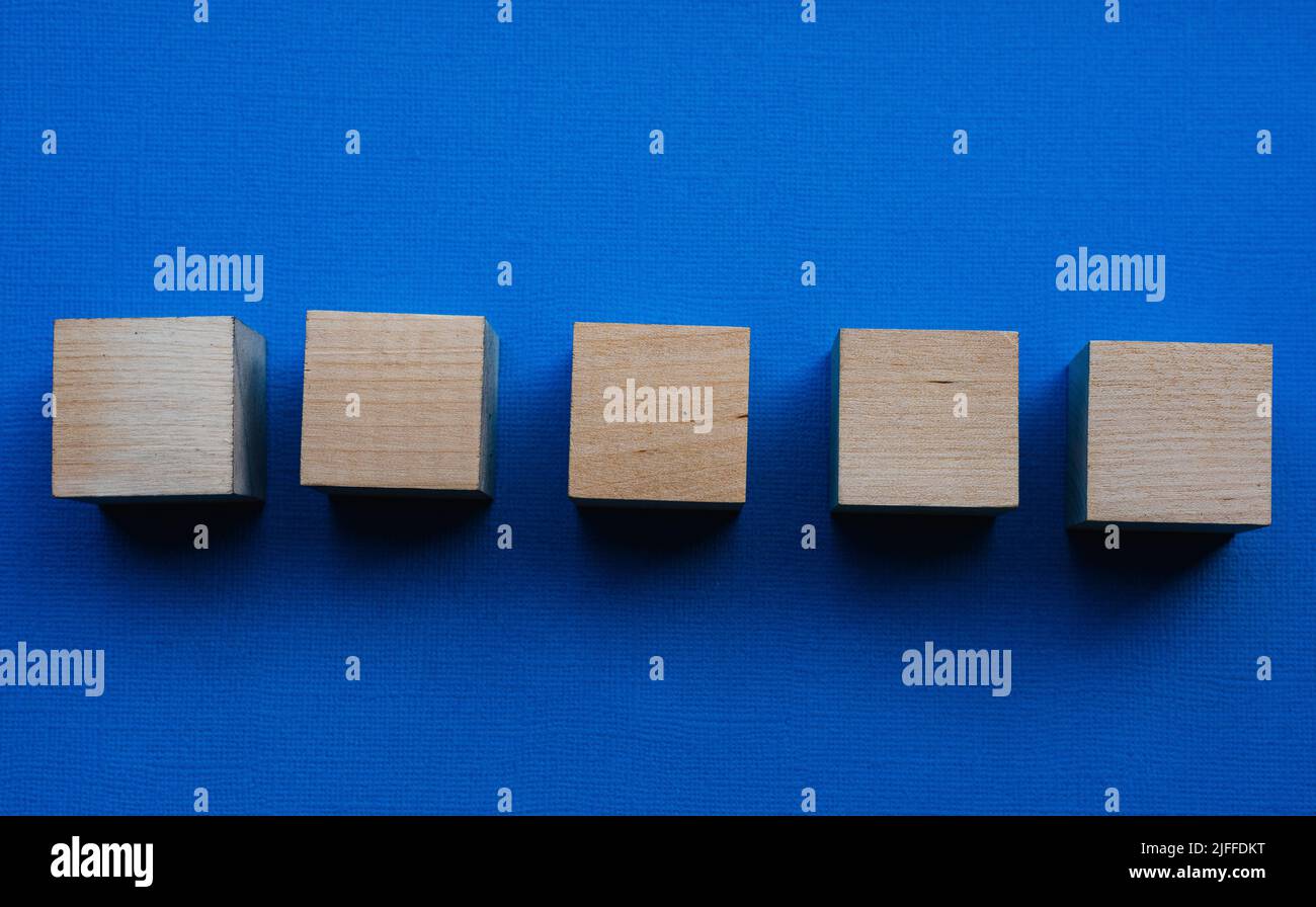 Five wooden cubes on a blue background, mocap Stock Photo - Alamy