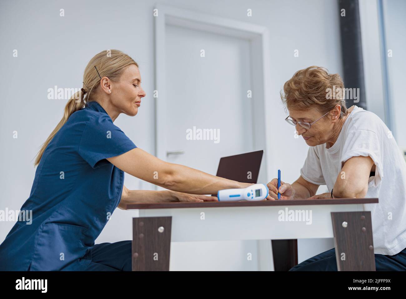Female patient signing treatment agreement in doctor's office in clinic ...