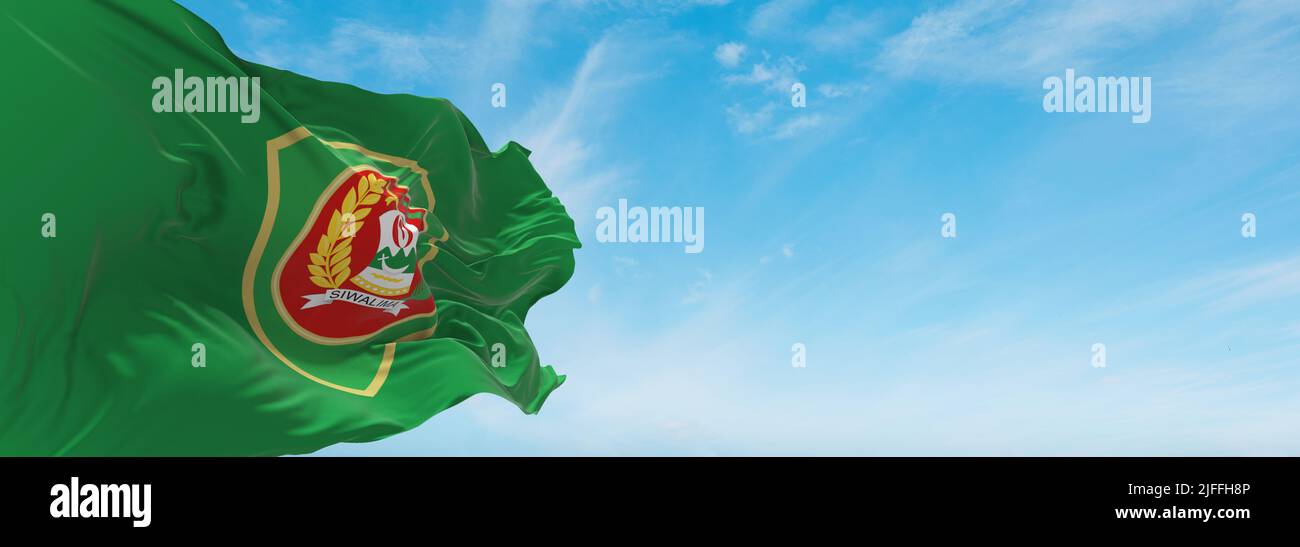 official flag of Maluku Indonesia at cloudy sky background on sunset ...