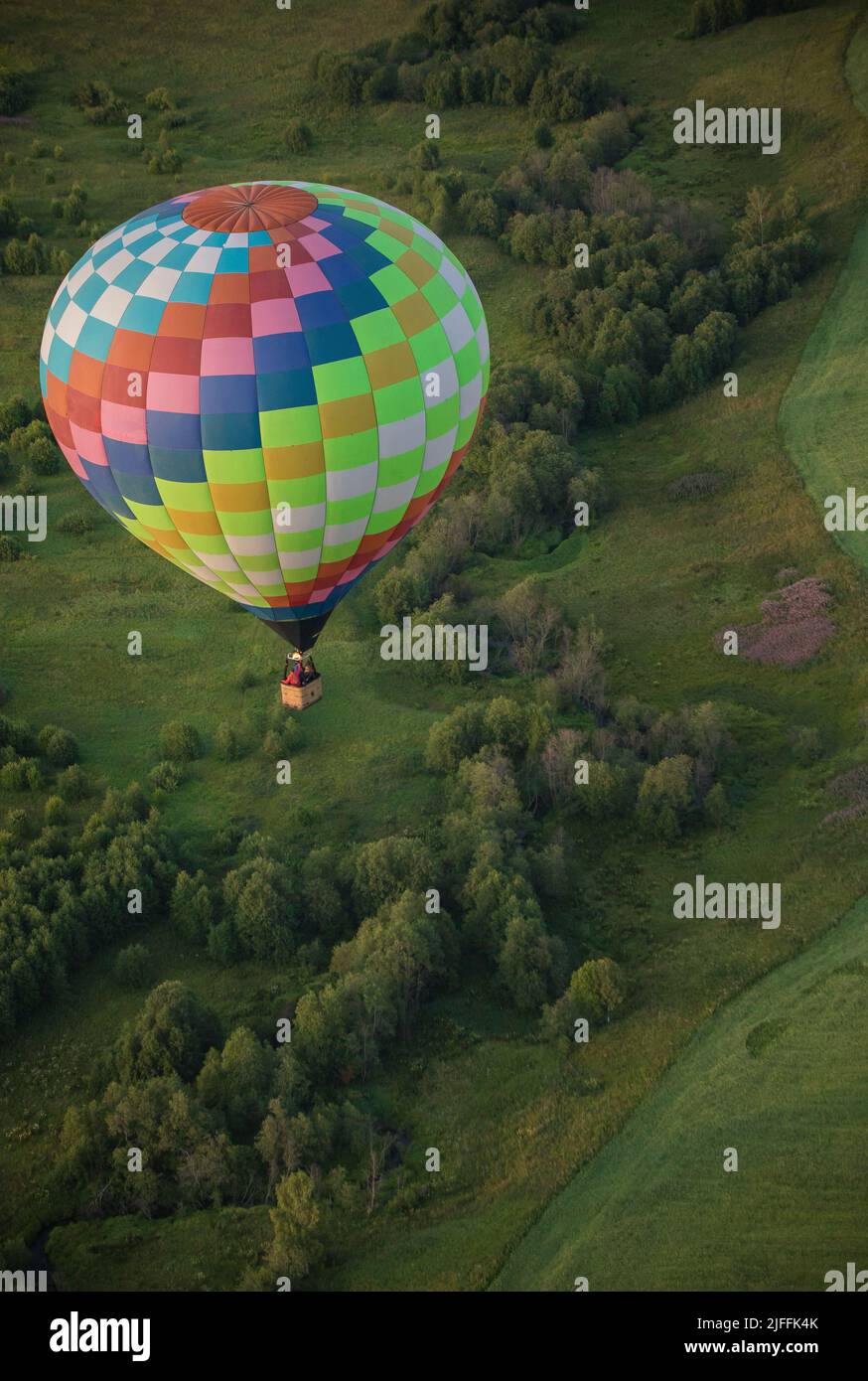 A big colorful balloon flying over the field using heat technology ...