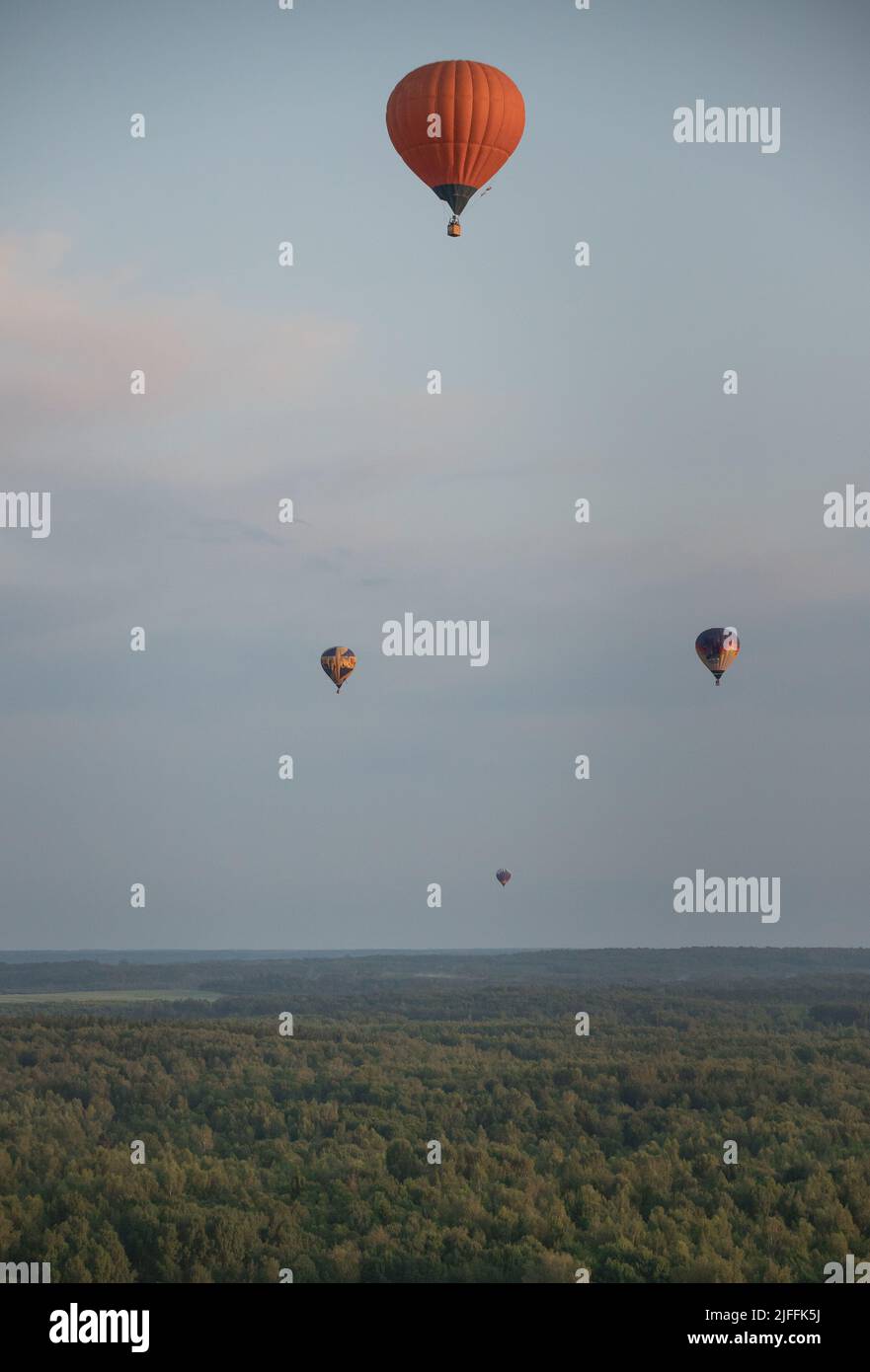 Four colorful balloons flying over the field using heat technology ...