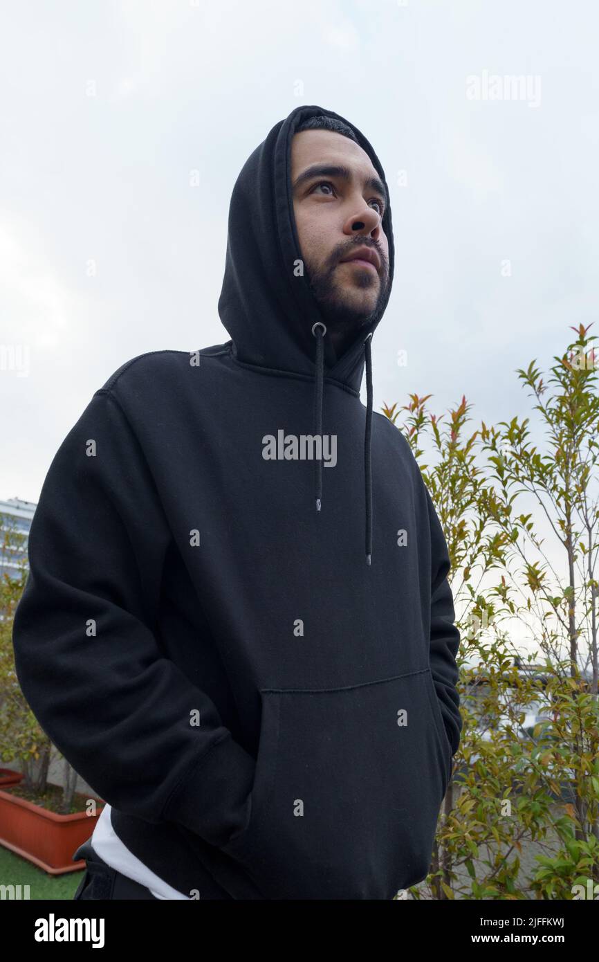posing standing wearing the hood of a sweater, urban fashion in the ...
