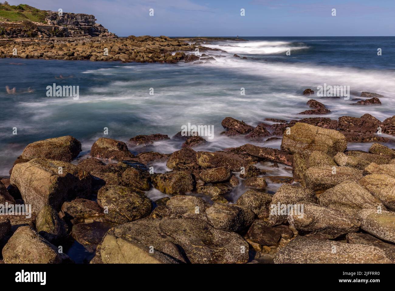 Long exposure landscape - sea waves washing into rocks in Clovelly ...