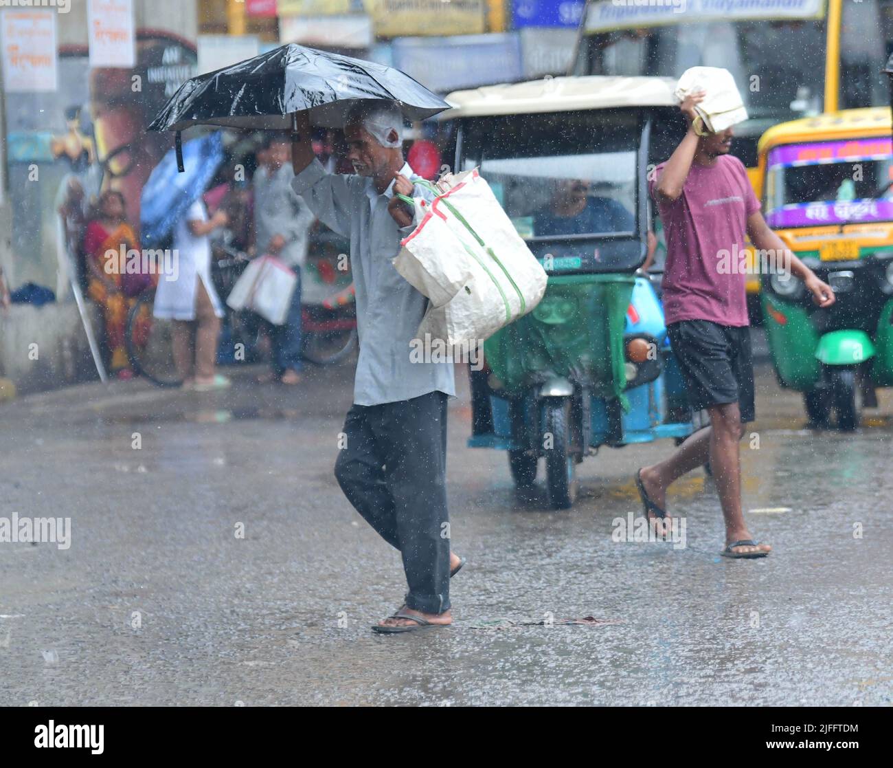Commuters walk during heavy rains in Agartala. Tripura, India Stock ...