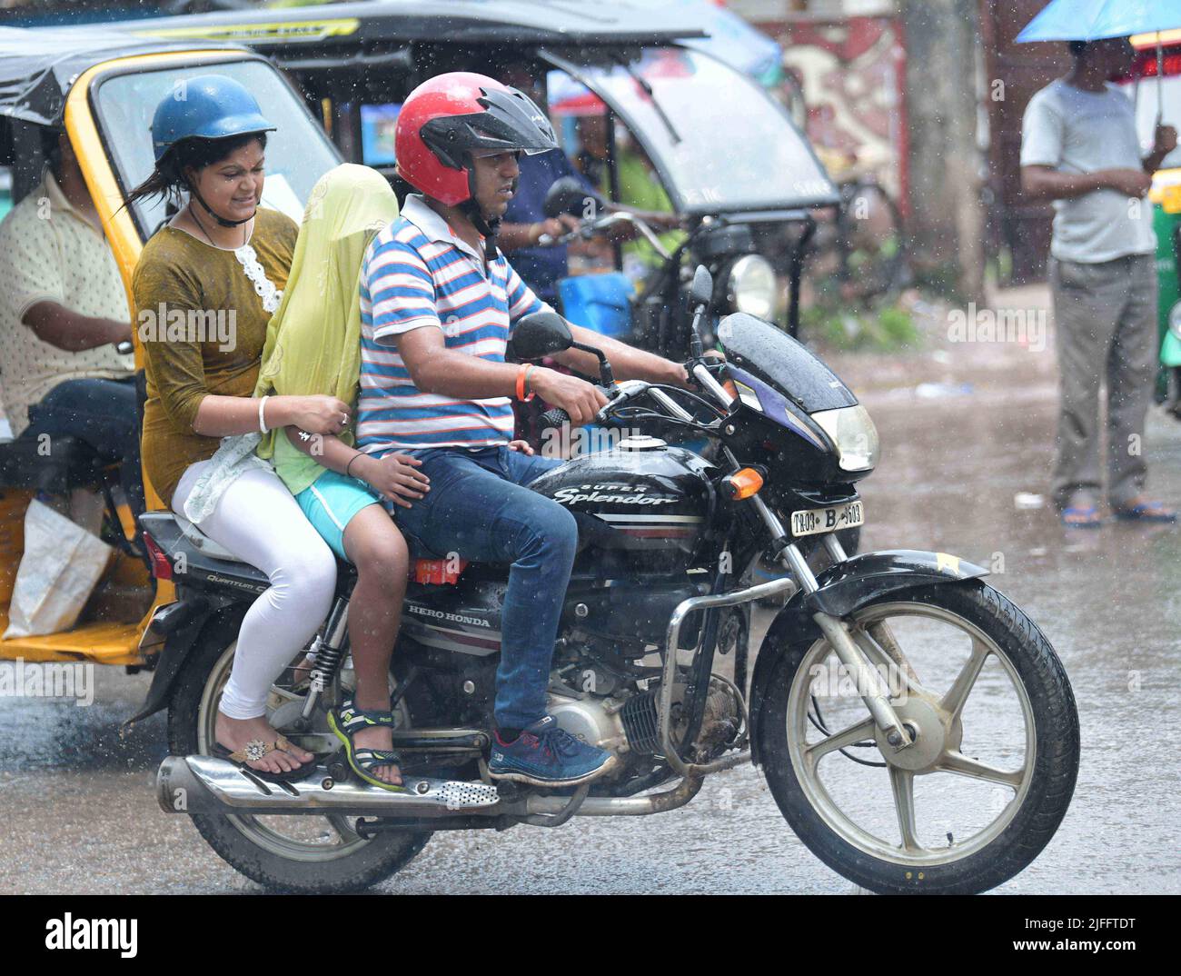 Commuters traveling by bike during heavy rain in Agartala. Tripura ...