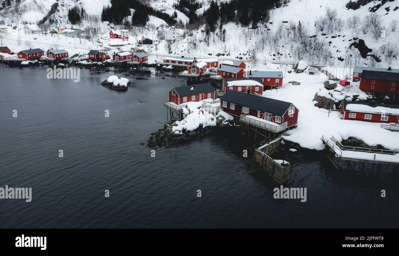 A calm freezing lake and a snow-covered village in the countryside ...
