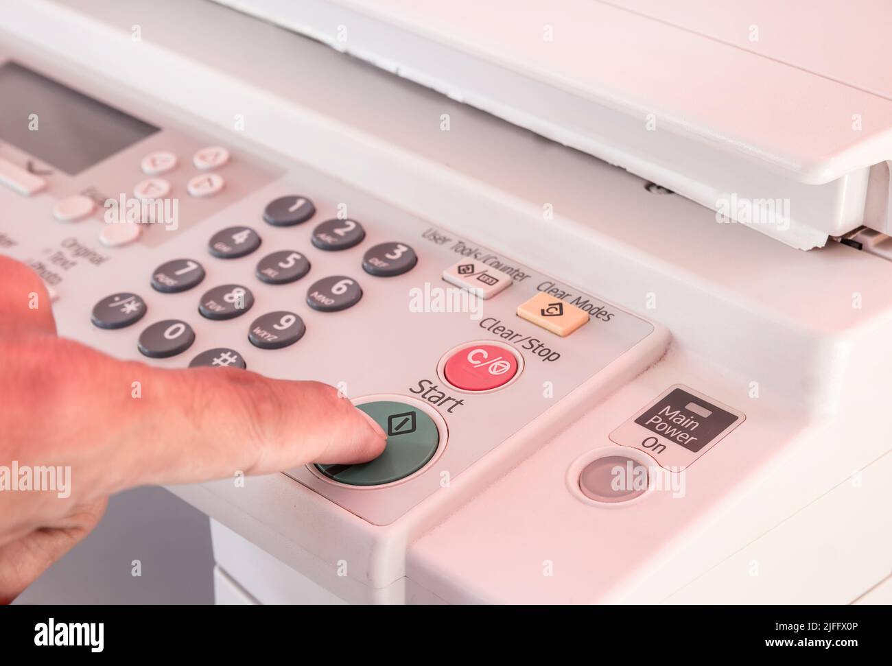 Hand pressing Start button on copy machine Stock Photo - Alamy