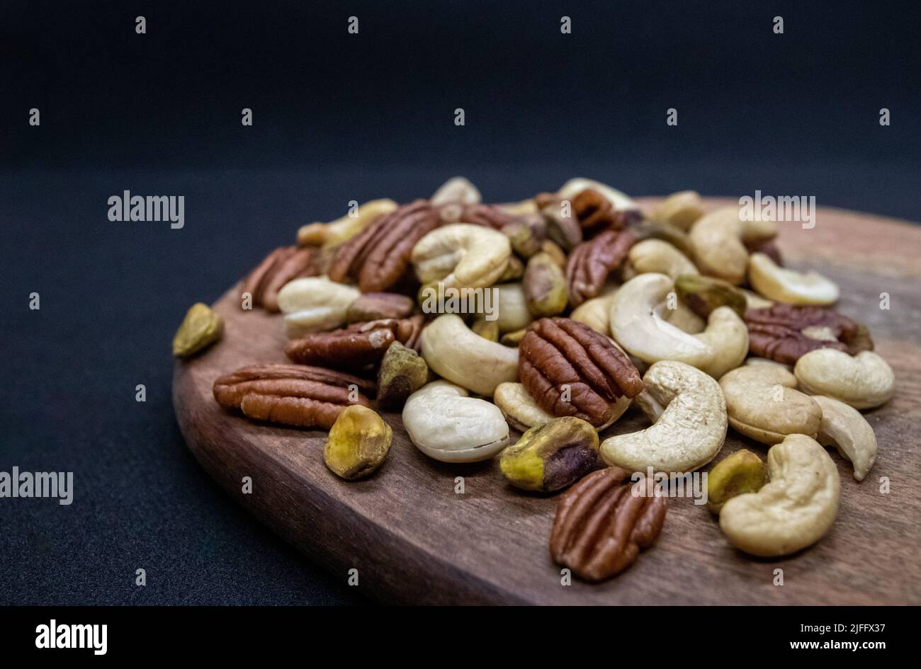 mix of raw nuts on the wood rustic board for healthy diet with organic ...