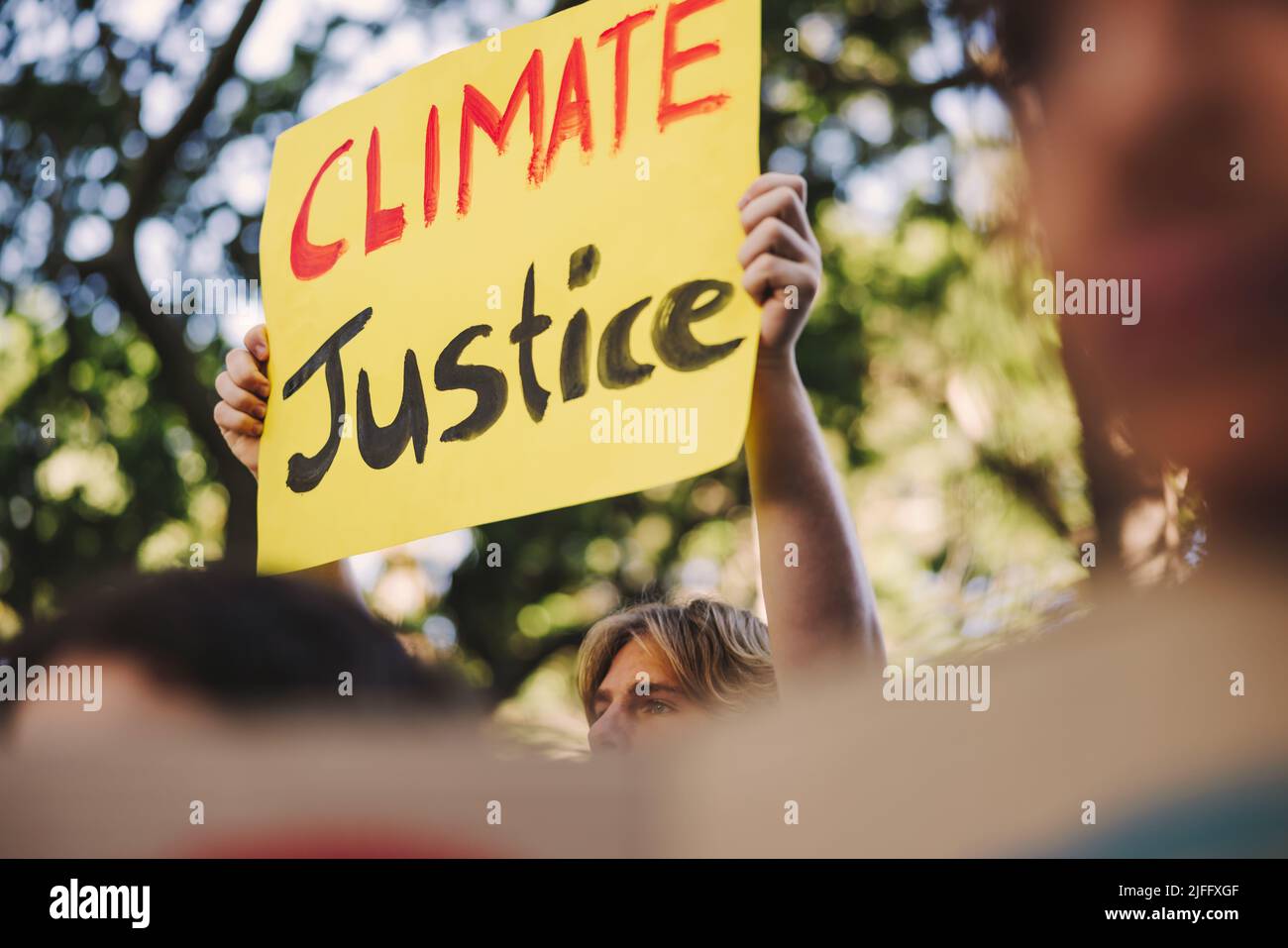 Movement for climate justice. Youth activist raising a poster while ...