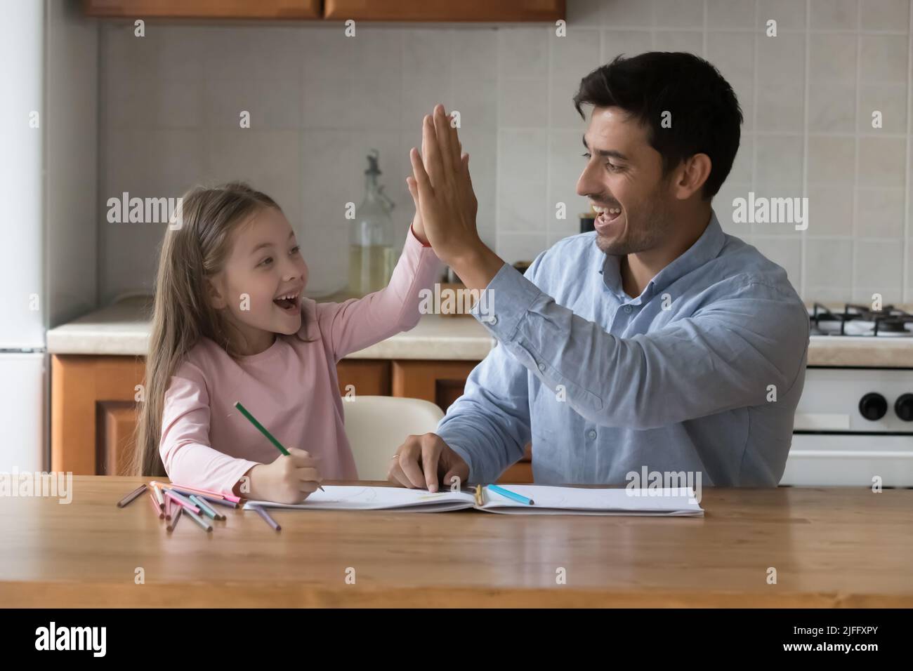 Father giving high five praising daughter for success in paintings ...