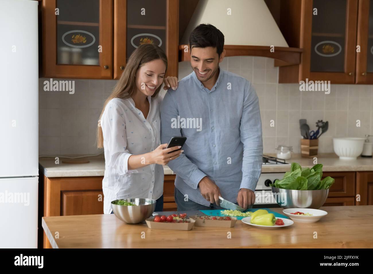 Couple using cellphone making food order while cooking lunch Stock ...