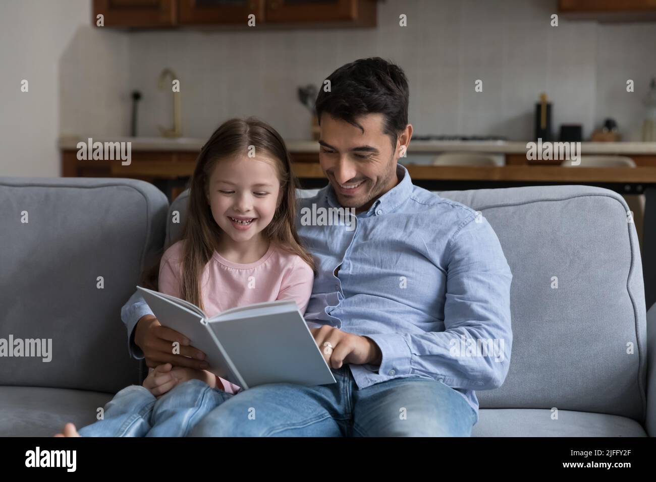 Loving father reads a book to little cute daughter Stock Photo - Alamy