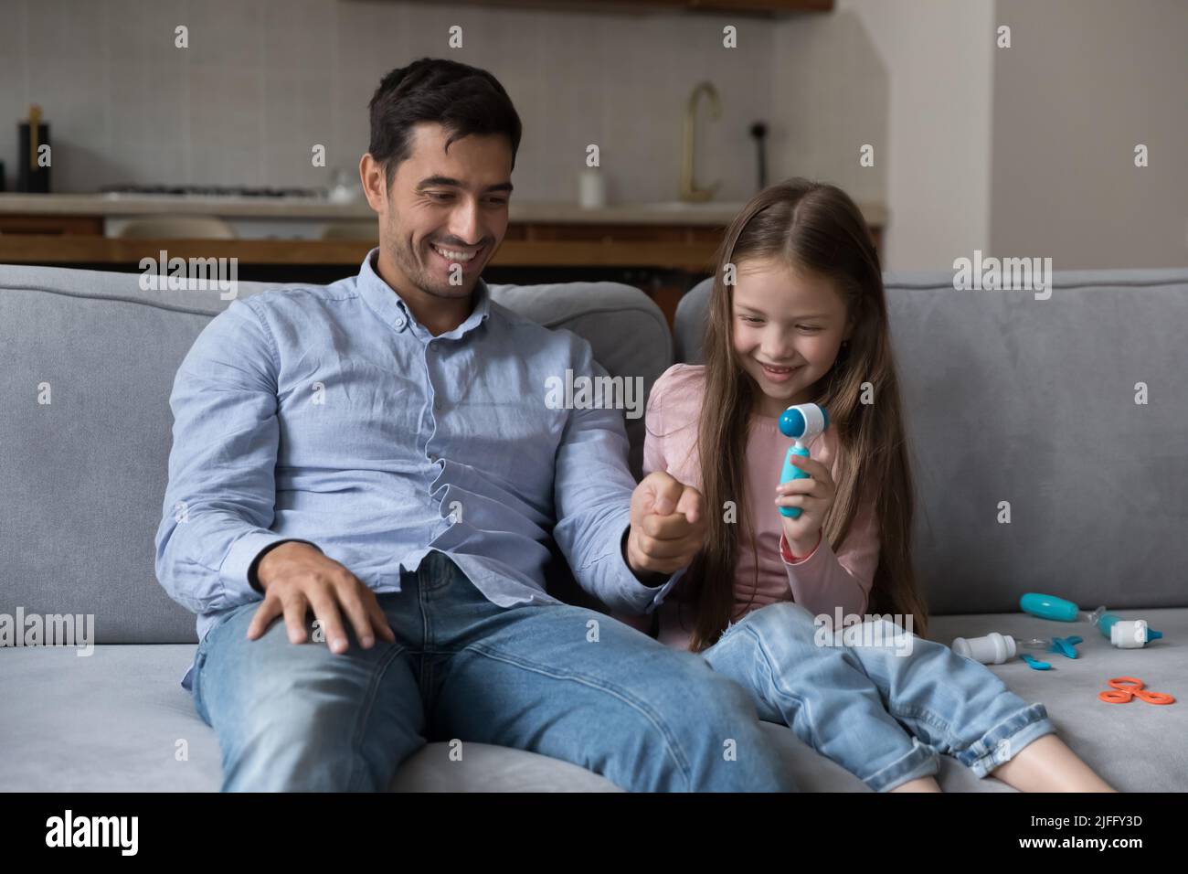 Daughter pretend be doctor, treats her father play toys set Stock Photo ...