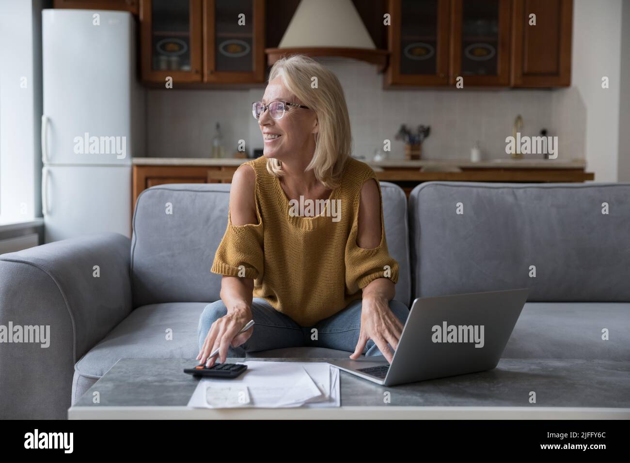 Happy older woman distracted from finances management smile staring ...