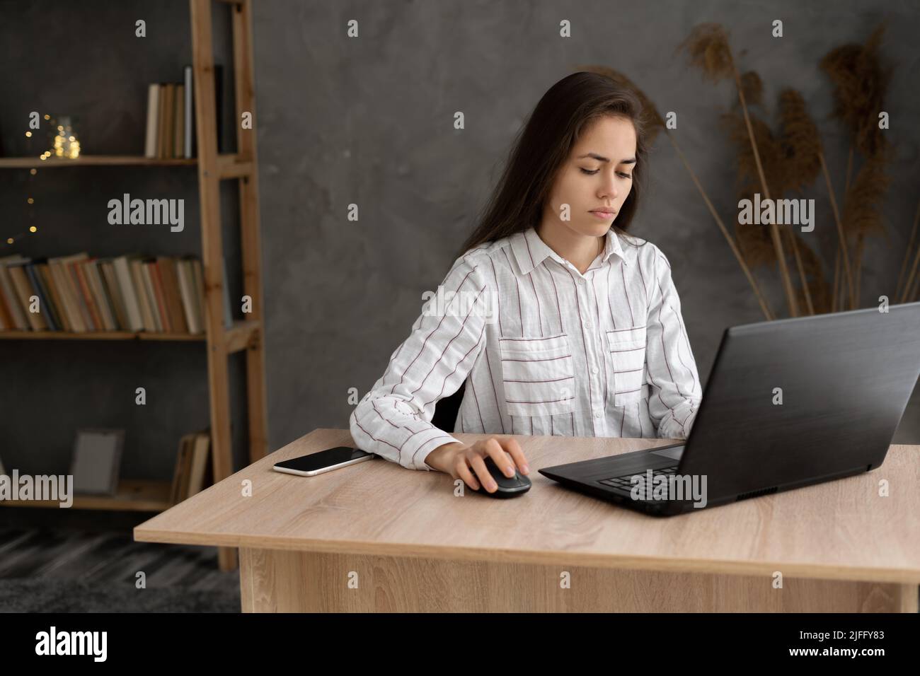 pretty brunette woman typing email on laptop computer while sitting ...