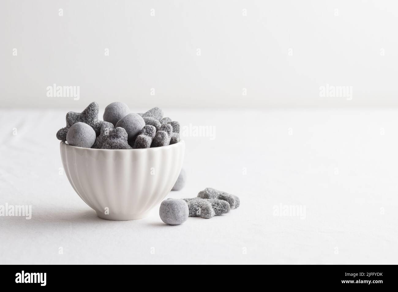 Salty liquorice salmiakki in Finnish in a white bowl with copy space ...