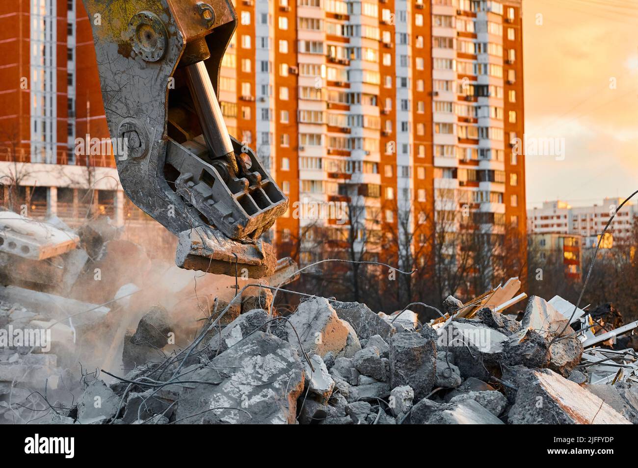 Crusher destroys reinforced concrete at demolition site Stock Photo - Alamy