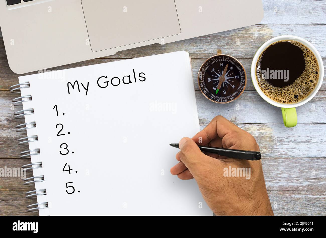 My Goals written on a blank notepad with laptop computer,pencil and cup ...