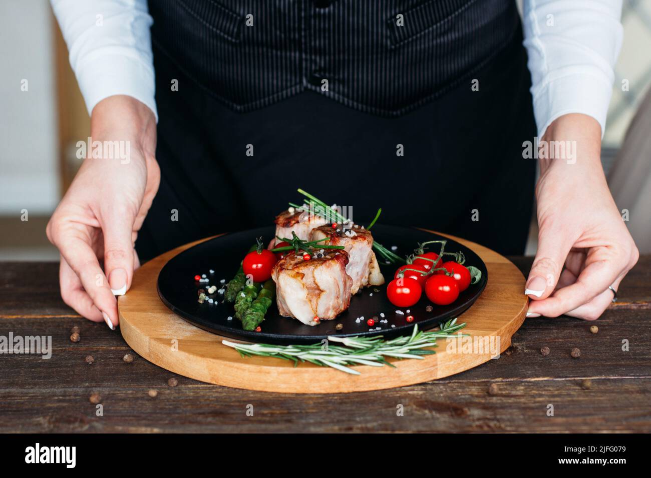 Food serving. Chief serving a pork dish Stock Photo - Alamy