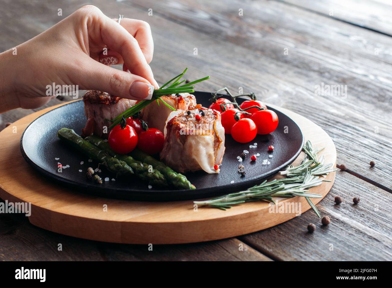 Food decorating. Chef decorating a pork dish Stock Photo - Alamy
