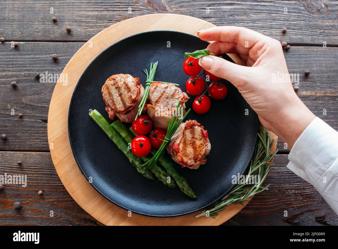 Food stylist. Chef decorating a pork dish Stock Photo - Alamy