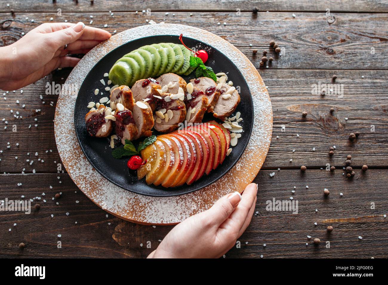 Waiter serving baked veal with fresh fruits Stock Photo - Alamy