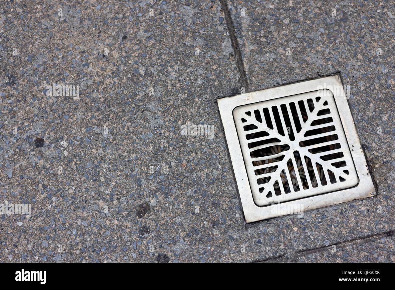 A high-angle view of a drain grate filled with cigarette butts Stock ...