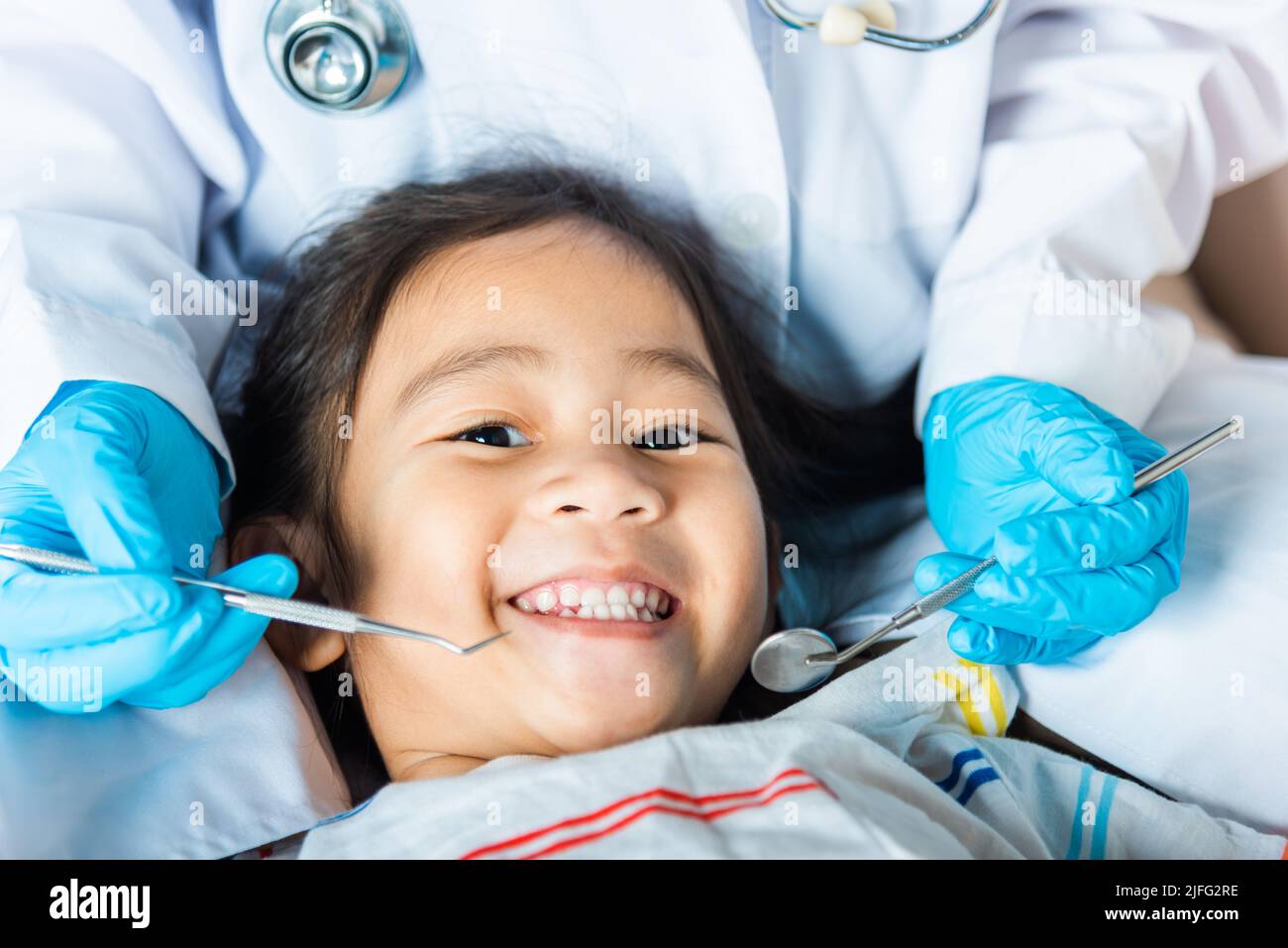 Dental kid health examination. Doctor examines oral cavity of little ...