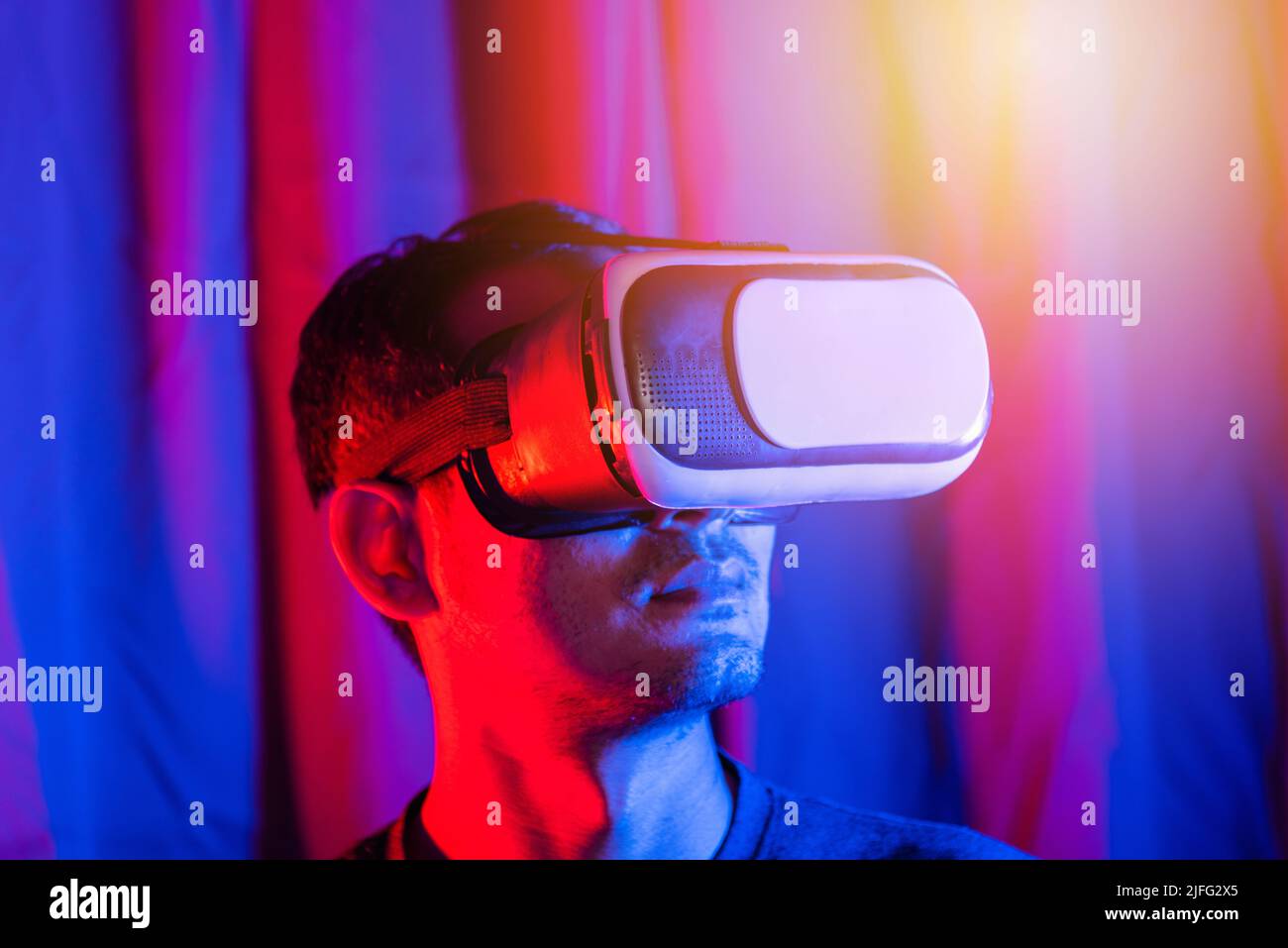 Asian handsome man wear VR helmet excited emotional at home purple and ...