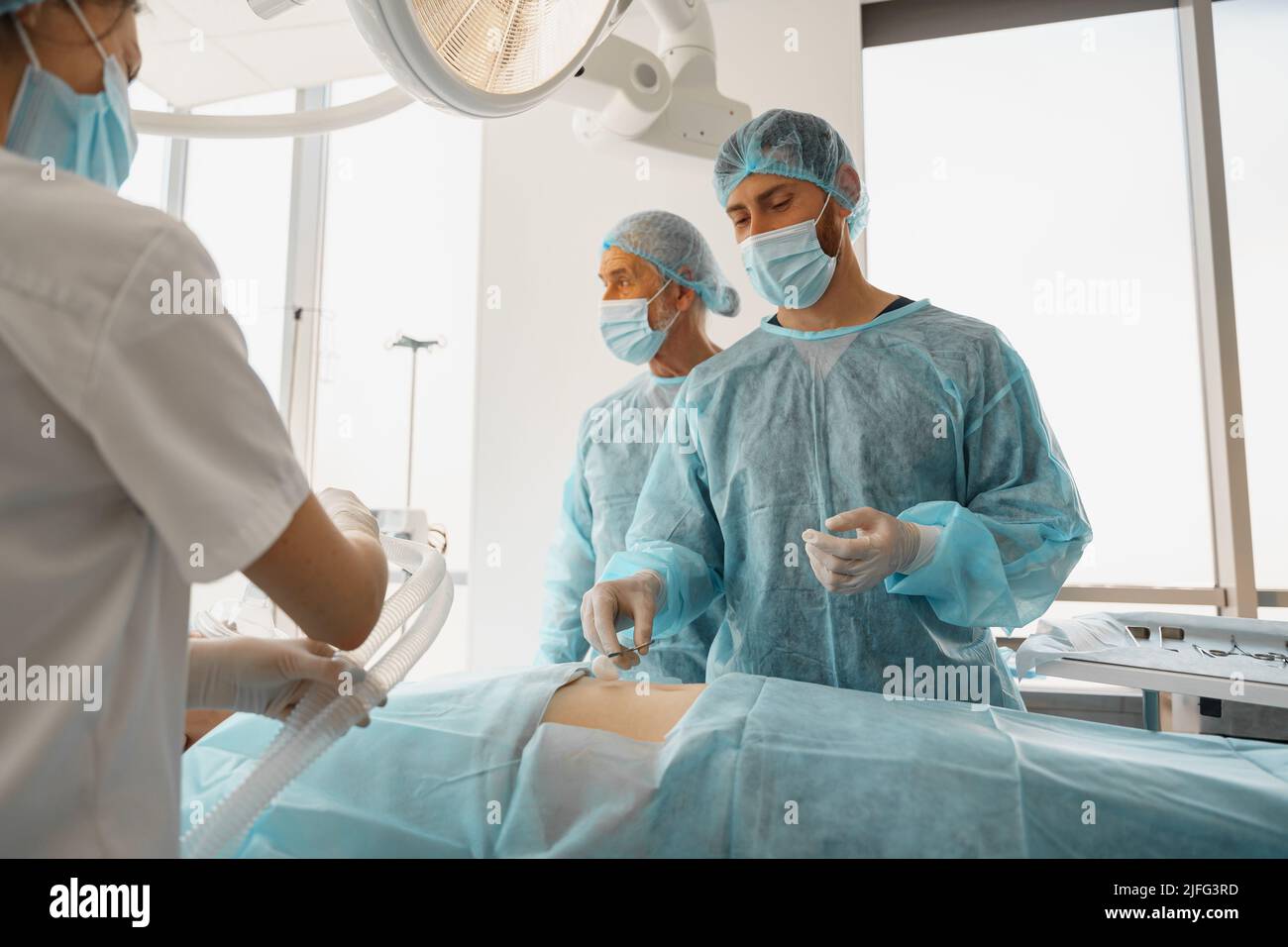 Nurse and doctor prepare patient skin for surgery using antiseptic ...