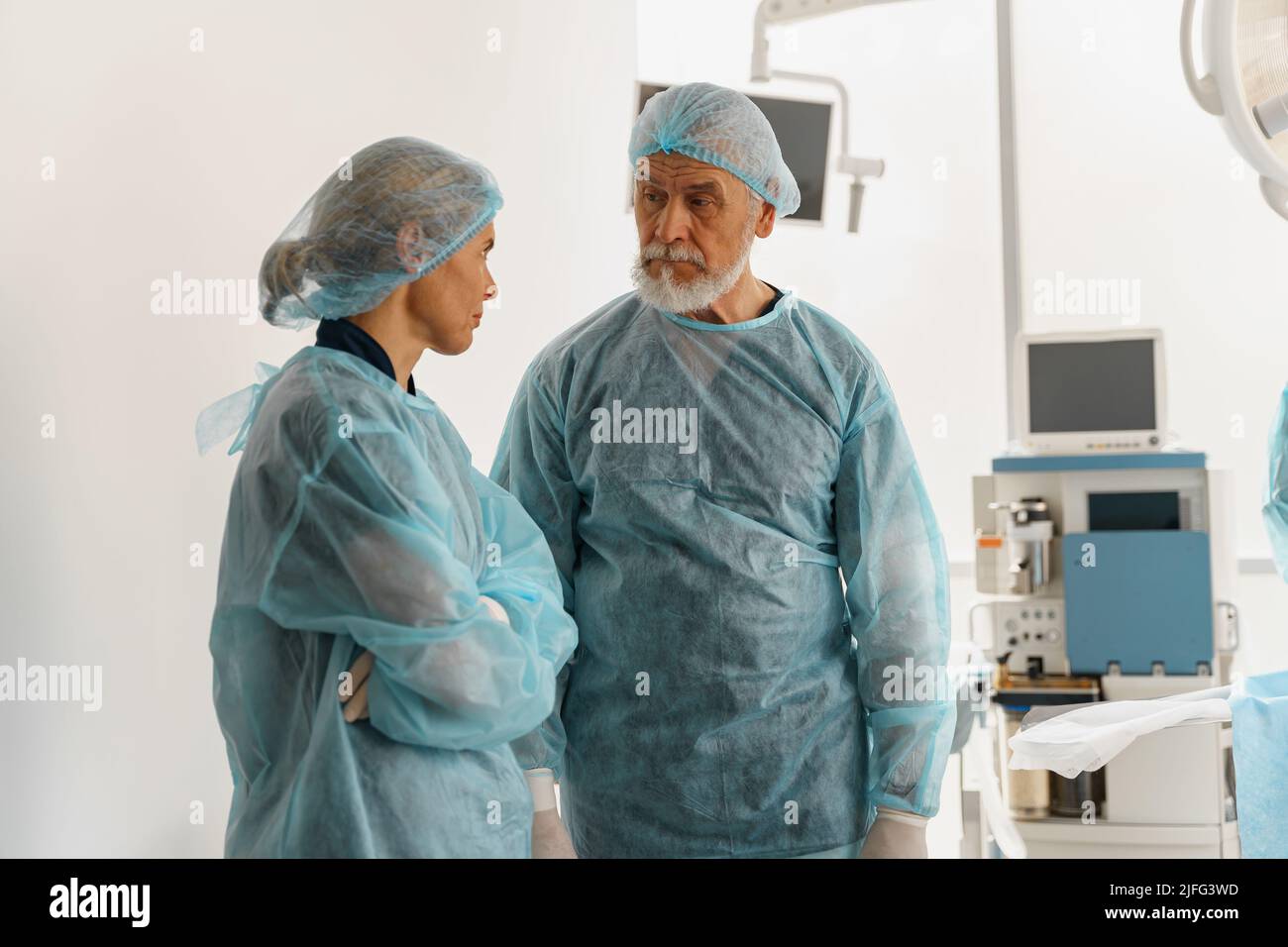 Two doctors surgeons are conferring in the operating room before the ...
