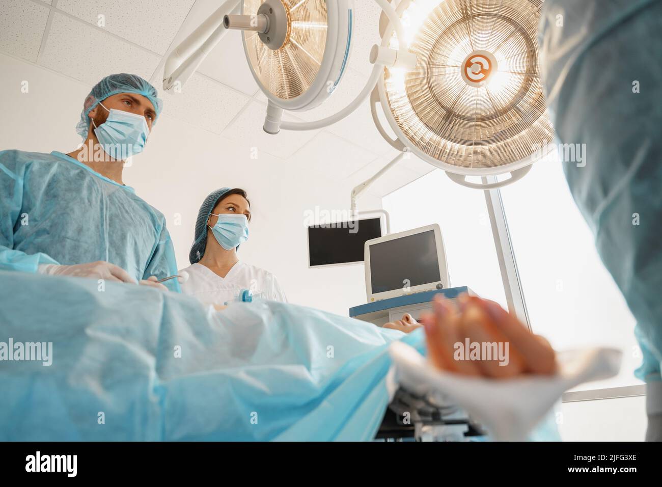 Focused surgical team working with a patient in an operation room Stock ...