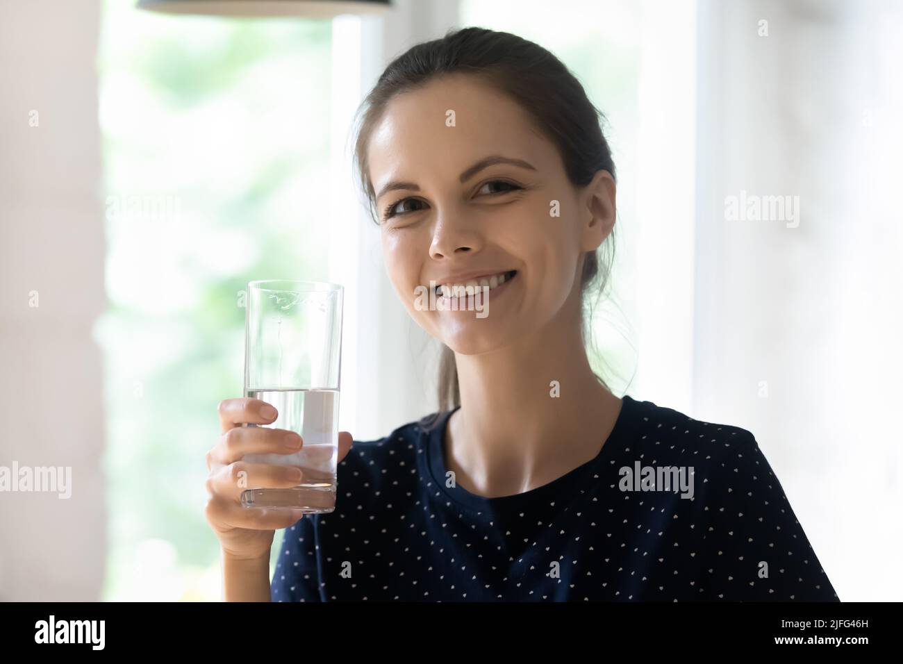 Happy cheerful beautiful girl holding clear transparent glass of water Stock Photo - Alamy