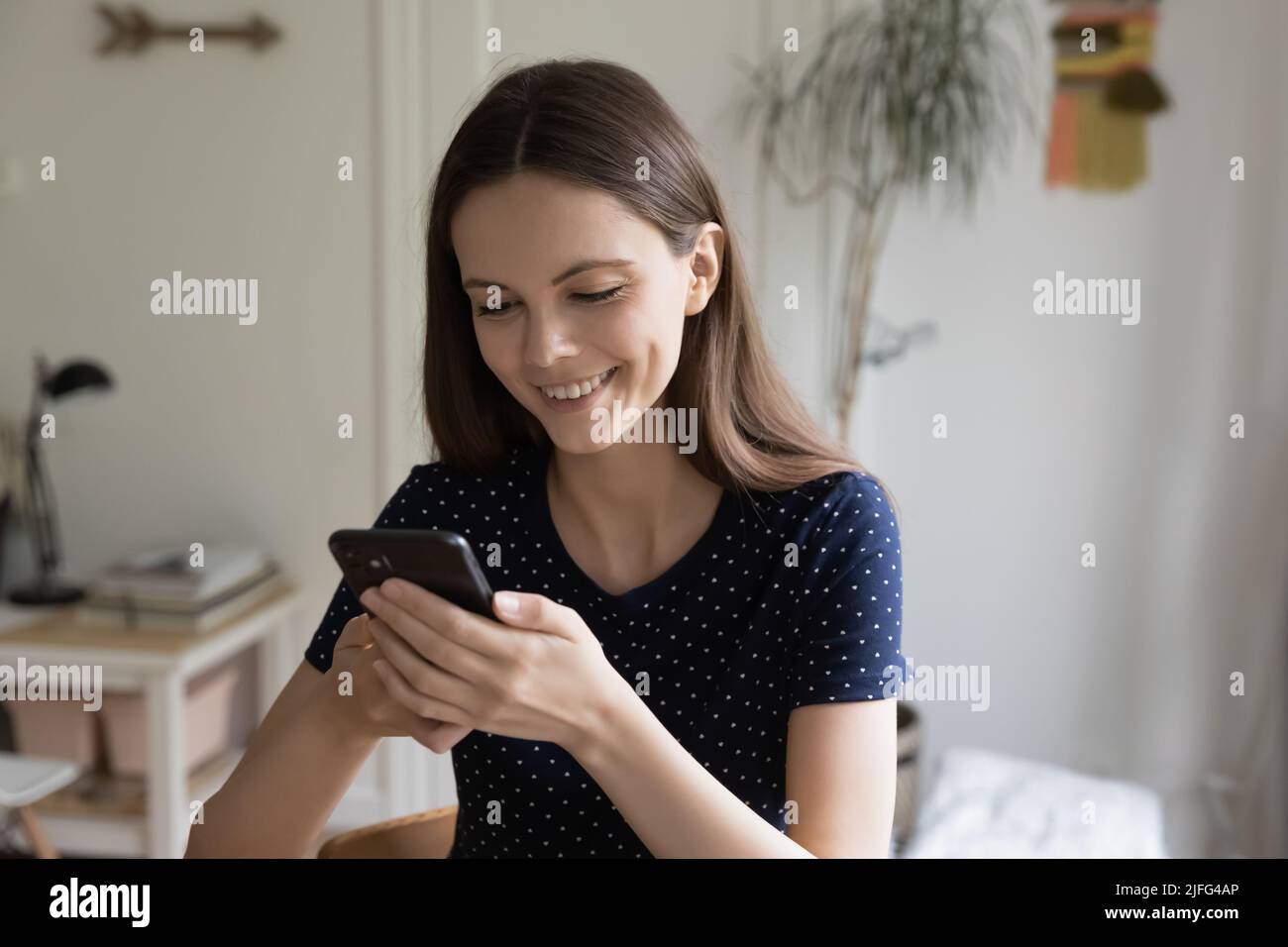 Happy Beautiful Millennial Girl Engaged In Using Mobile Phone Stock