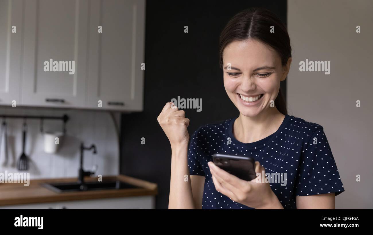 Joyful excited young smartphone user girl celebrating success Stock ...