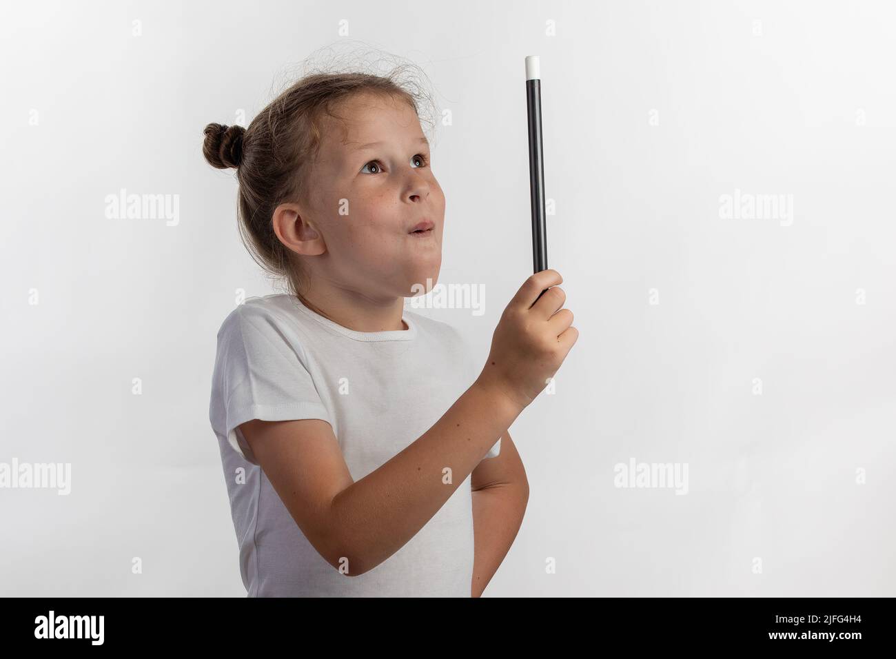 Girl magician holding up a magic wand - young magician performing with ...