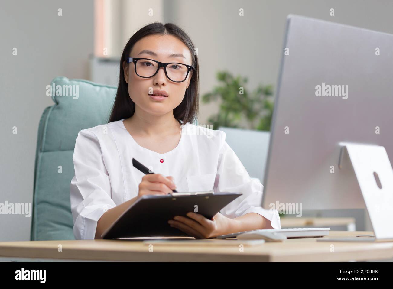 Portrait of young Asian female doctor, nurse woman looking at camera ...
