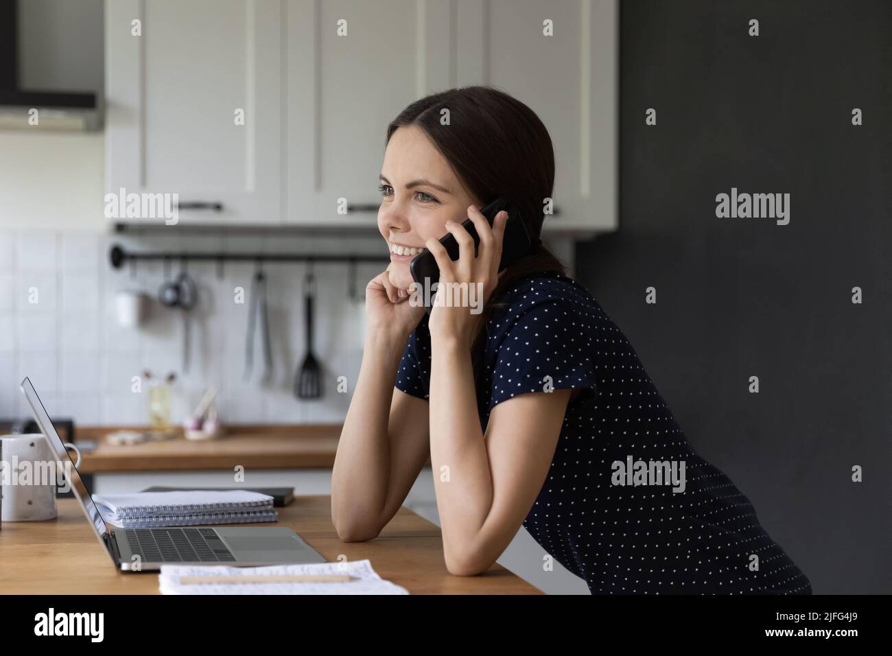 Happy cheerful young freelance employee woman giving telephone ...