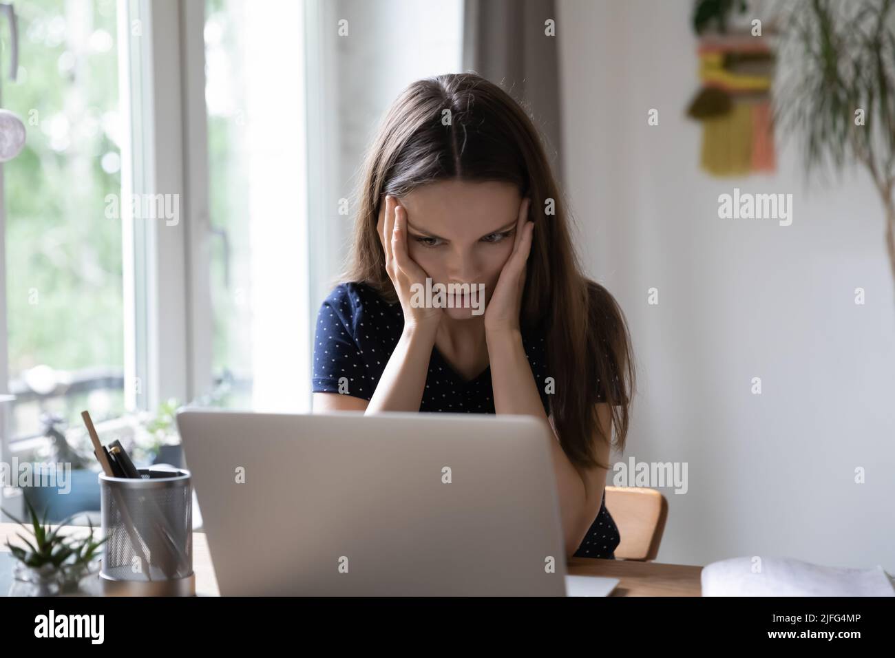 Stressed shocked young woman frustrated about problems with laptop ...