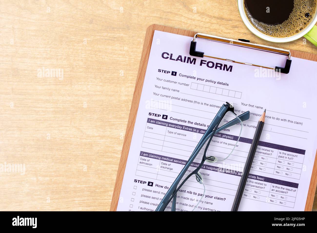 Medical claim form and glasses, pencil with cup of coffee on office ...