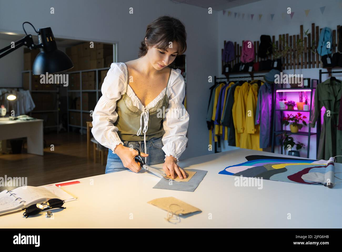 Garment sewing business, young female dressmaker work with textile in ...