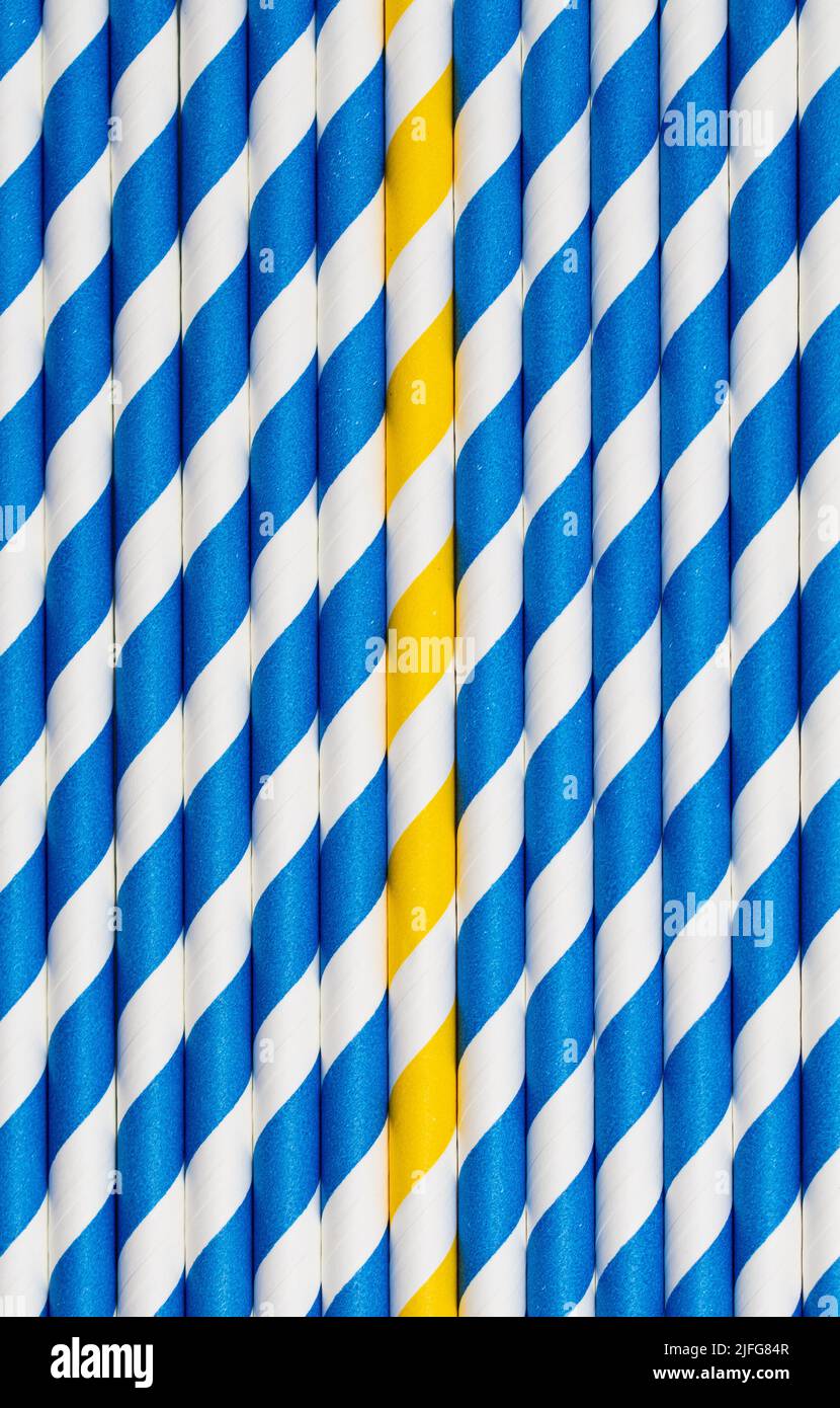 Full frame photo of blue and white straws from above, one yellow straw ...