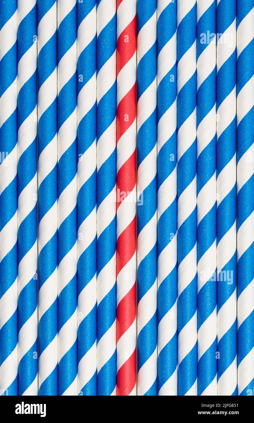 Full frame photo of blue and white straws from above, one red straw is ...