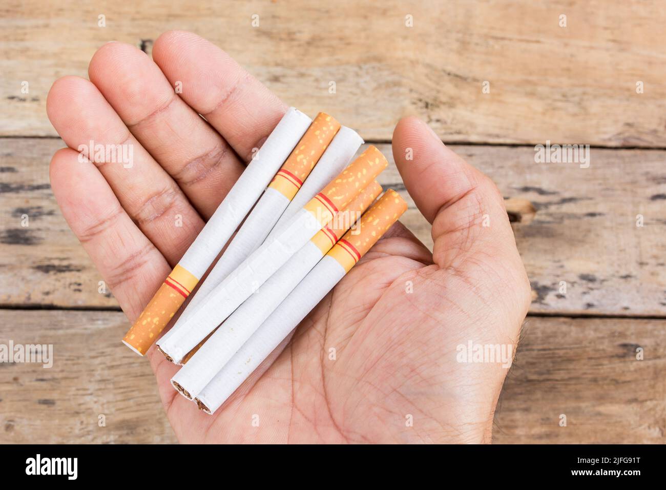 Close up cigarette roll in hand holding Stock Photo - Alamy