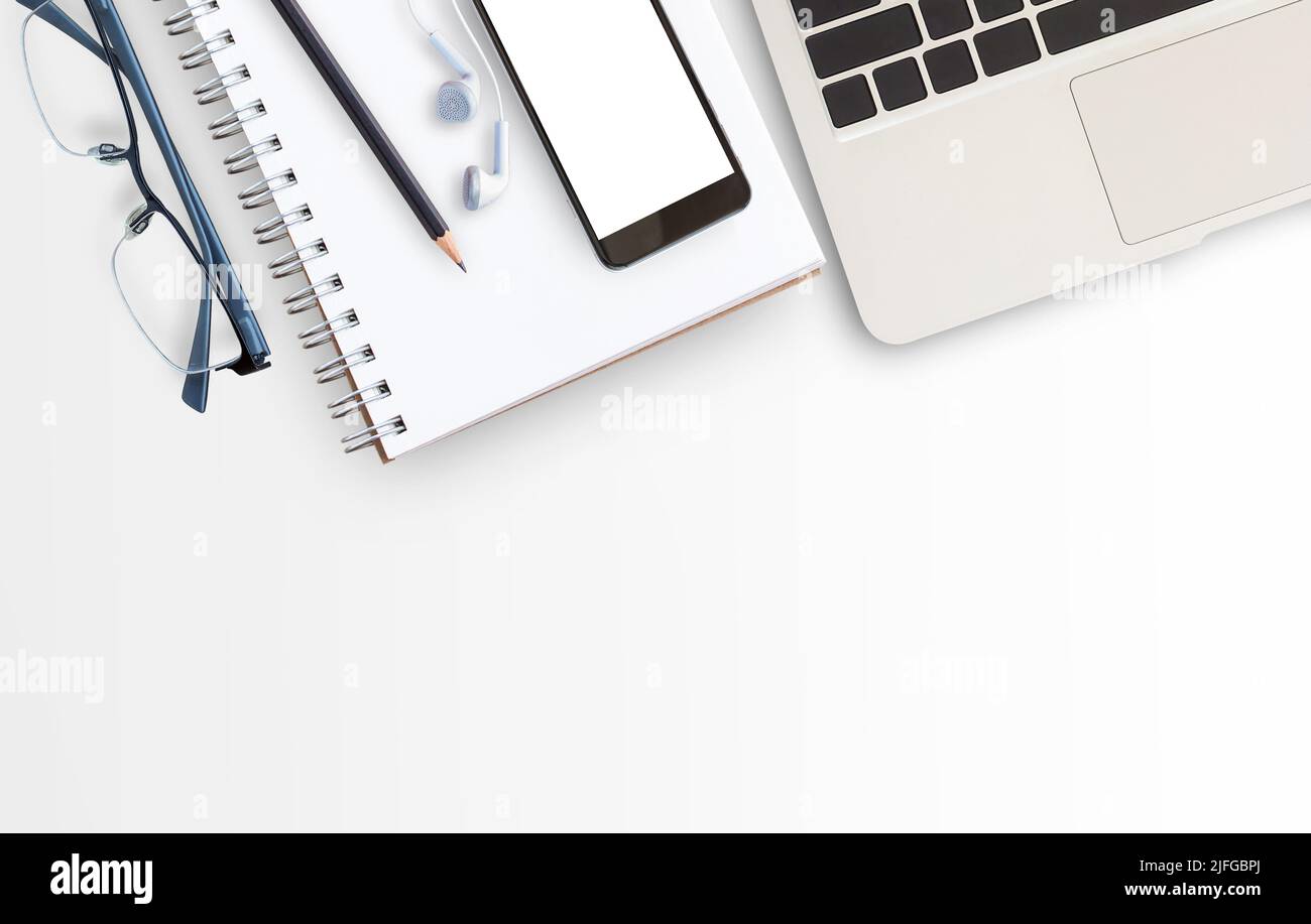 Blank paper notebook, laptop computer,glasses and smart phone on white ...