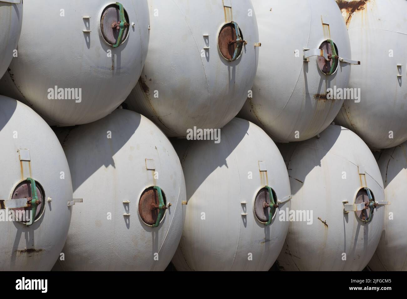 Two row of metal cilindrical containers Stock Photo - Alamy