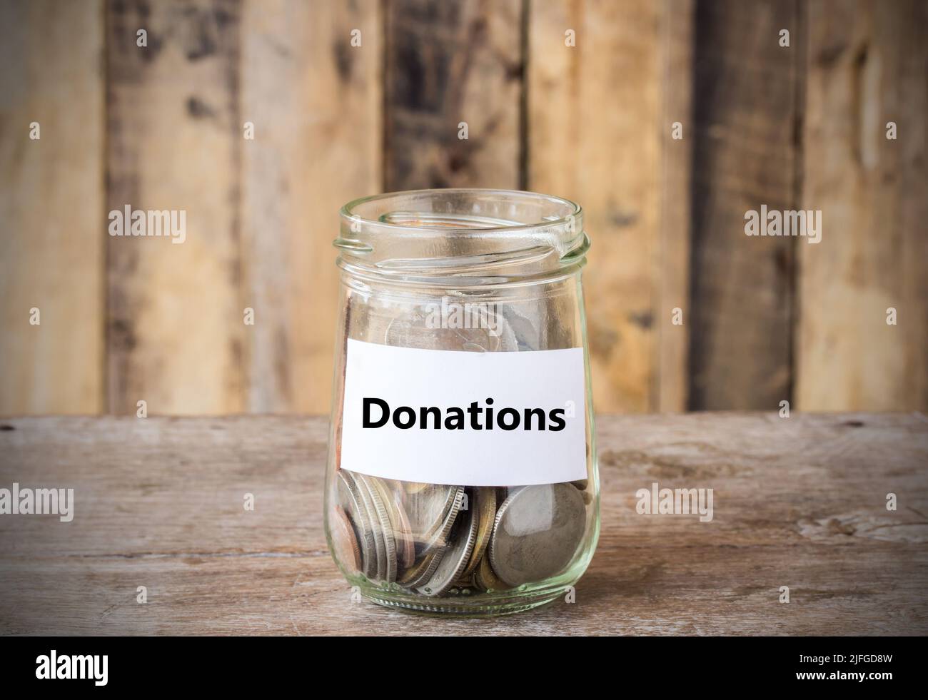 Coins in glass money jar with donations label, financial concept ...