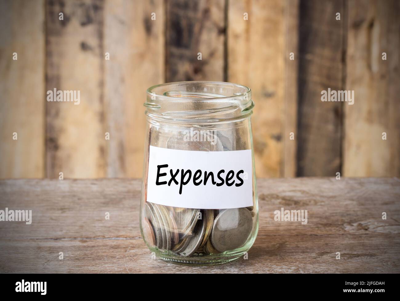 Coins in glass money jar with expenses label, financial concept ...